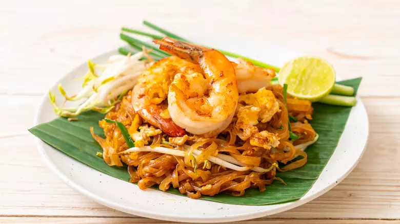 pad thai dengan udang di piring daun