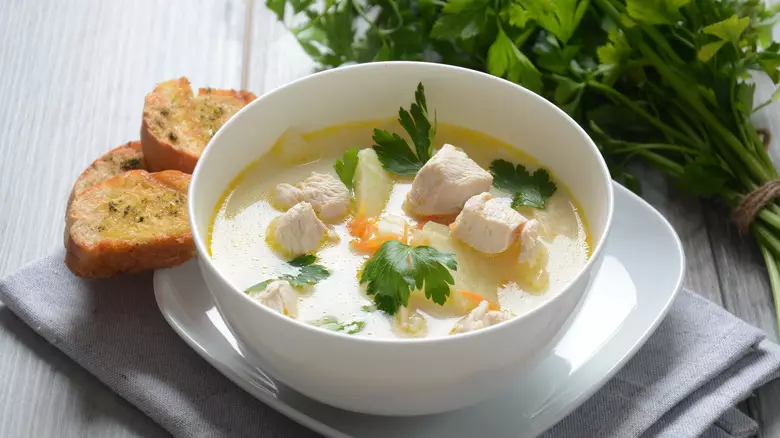 Sopa de polo con verduras nunha mesa.