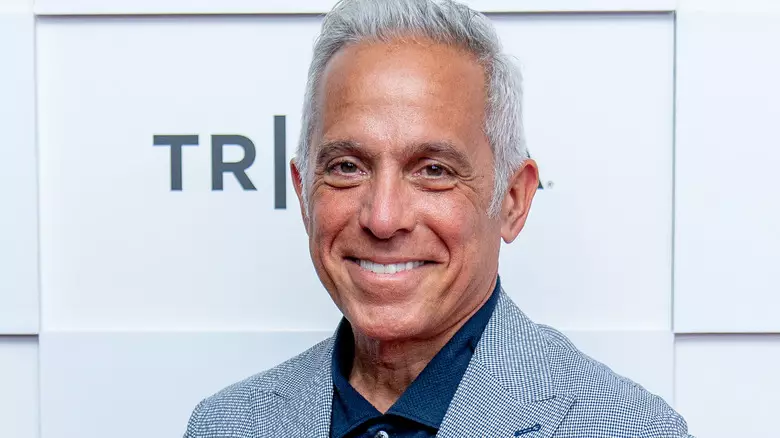 Geoffrey Zakarian yana murmushi sanye da kaya shudi