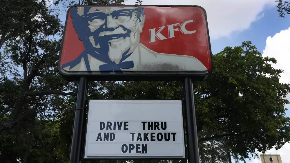 Oxucu lövhəsi ilə KFC işarəsi: