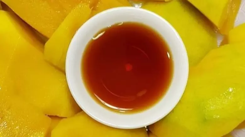 Vissaus omgeven door plakjes mango