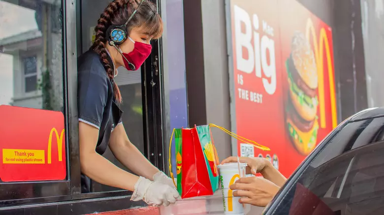 Ein Drive-Through-Mitarbeiter von McDonald's mit Gesichtsmaske