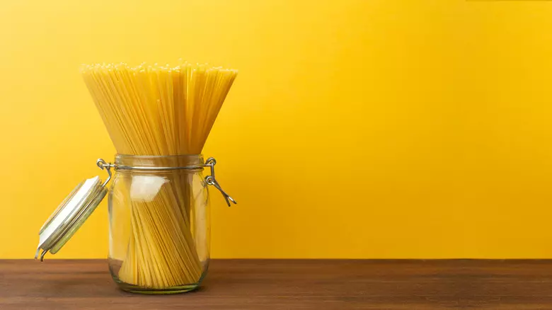 Balang spageti yang belum dimasak dengan latar belakang kuning