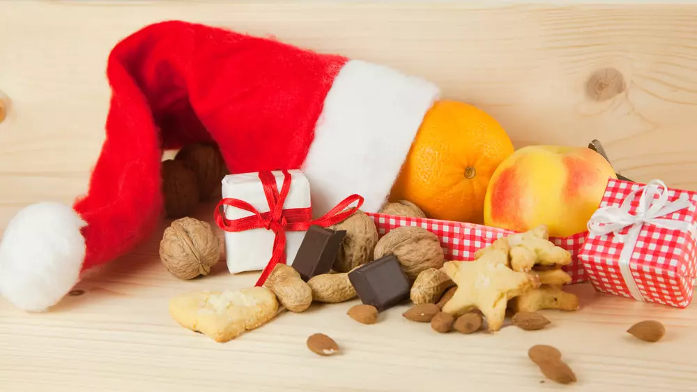 Laranxa, mazá, chocolate, noces e galletas nun gorro de Papá Noel