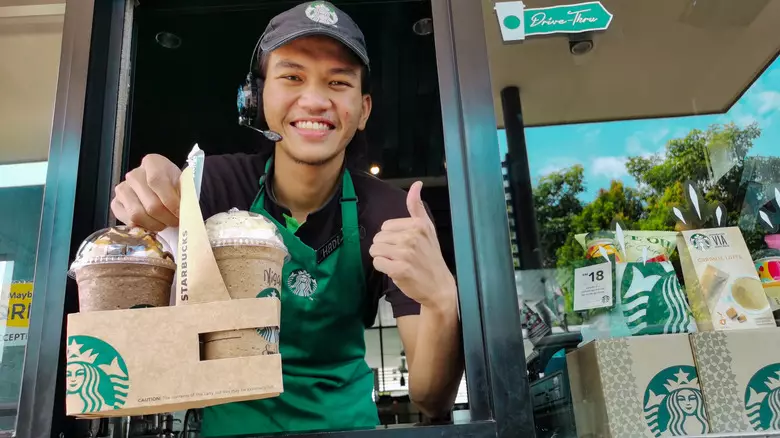 Сотрудник Starbucks показывает большой палец вверх