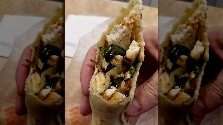 Niekto drží napoly zjedené kura Whataburger Fajita Taco