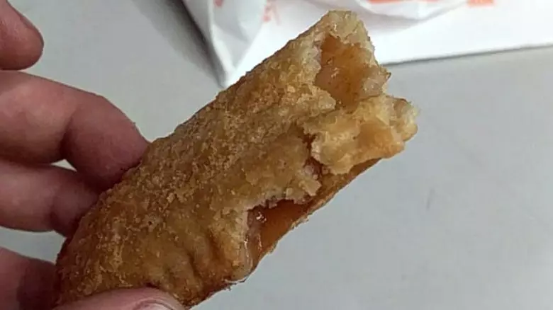 Persona in possesso di una torta di mele calda Whataburger