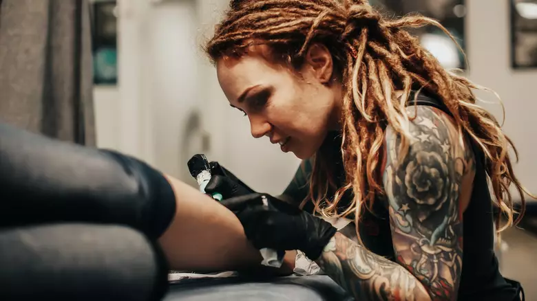 tatuador de mulher com dreadlocks