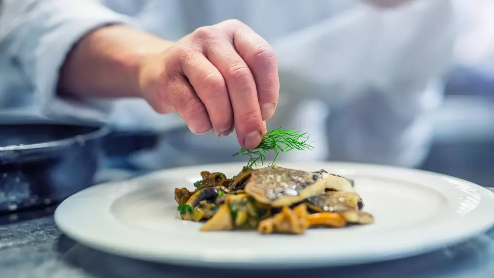 chef decorando um bife de peixe