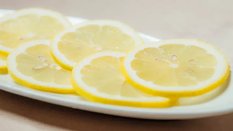 lemon sliced dị ntakịrị na efere ọcha