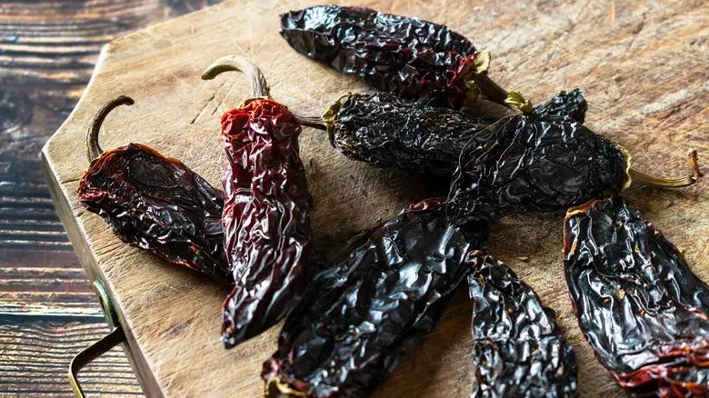 Chiles chipotles secos en una tabla para cortar madera