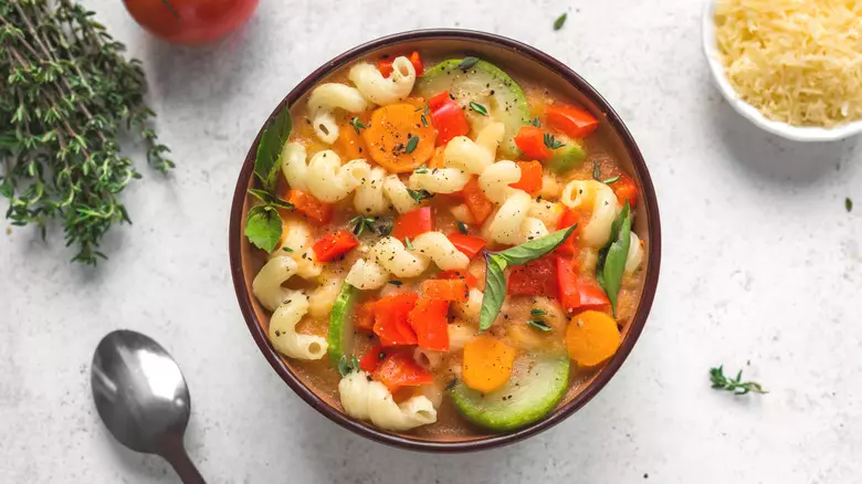 Un tazón de sopa minestrone en un tazón marrón