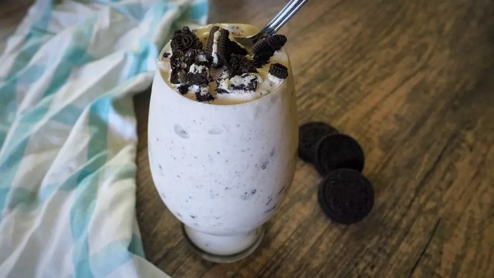 vaso de Oreo Blizzard casero sobre una mesa de madera con galletas Oreo