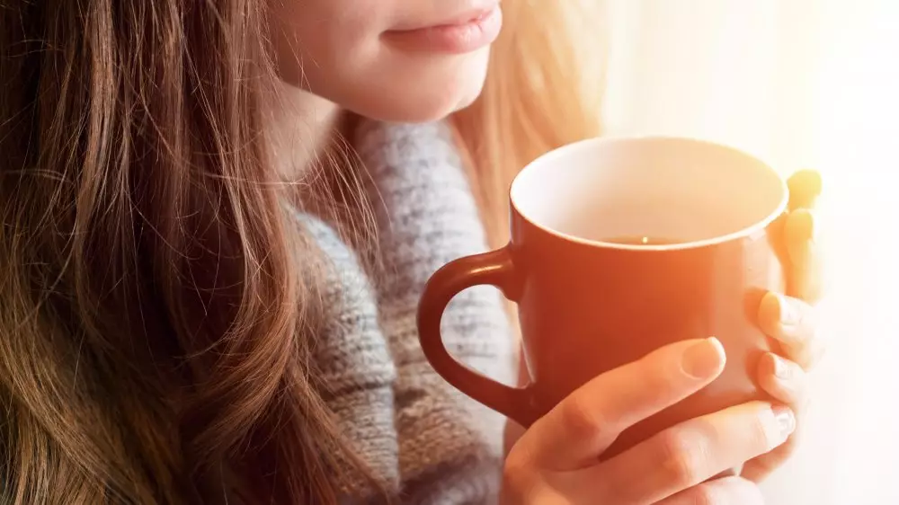 Mulher segurando uma xícara de chá para relaxar