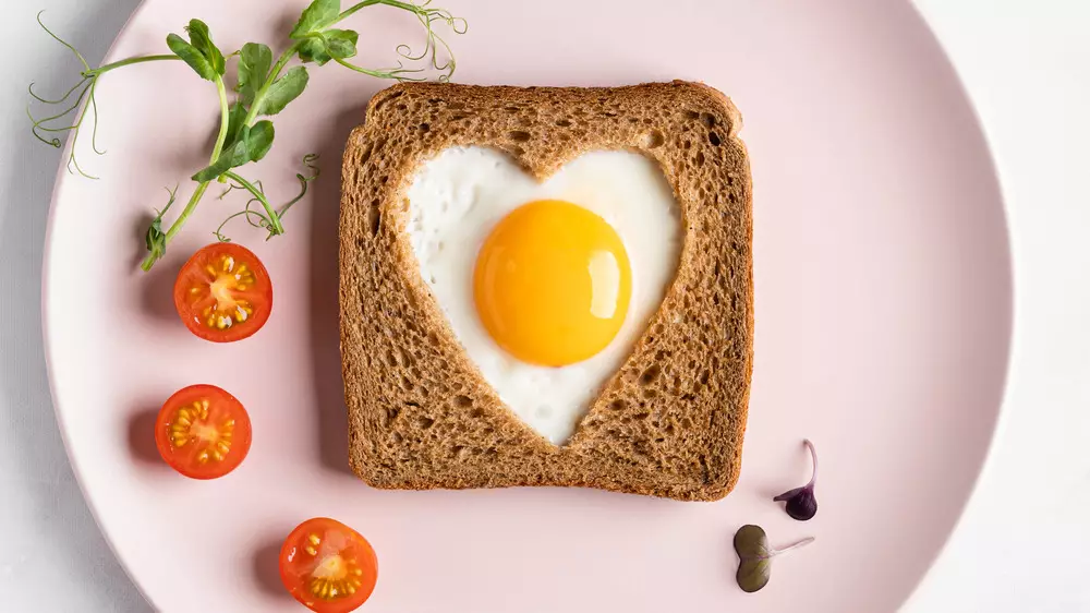 Варено яйце във формата на сърце върху филия препечен хляб