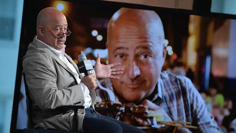 Andrew Zimmern dengan episod Bizarre Foods di sebelahnya pada skrin