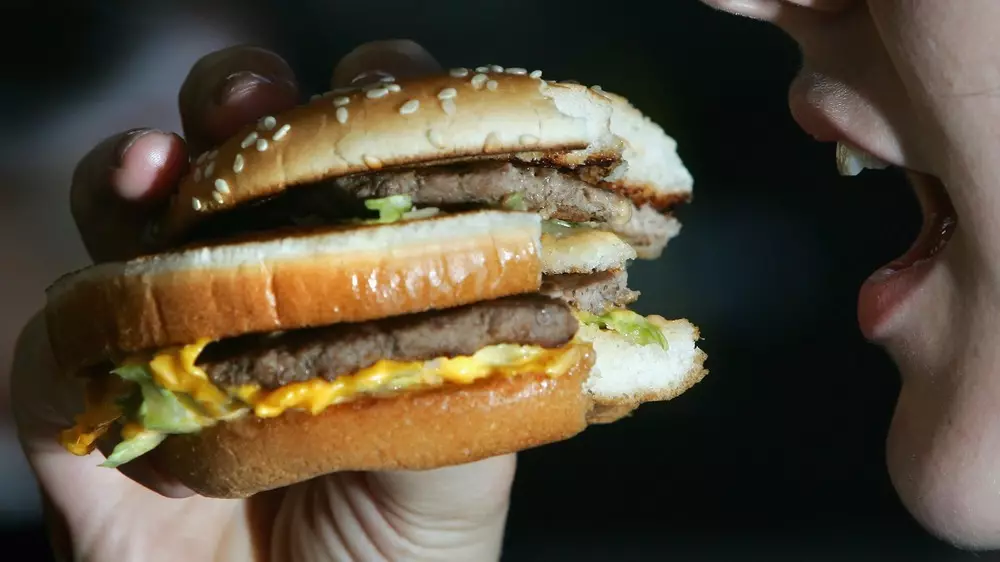 Donna che mangia un Big Mac di McDonald's