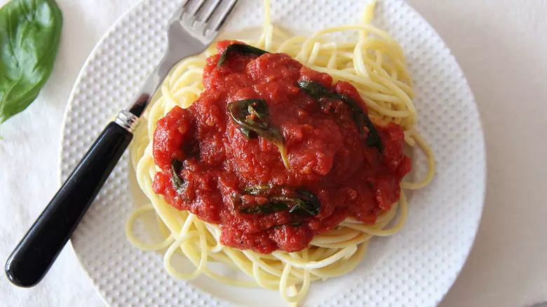 sauce marinara karo spageti ing piring putih