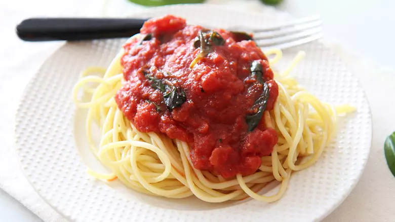 marinara sauce da spaghetti akan farar farantin