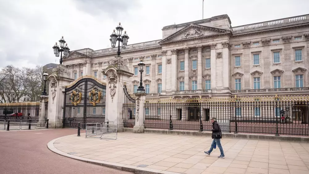 man voor Buckingham Palace op lege trottoirs