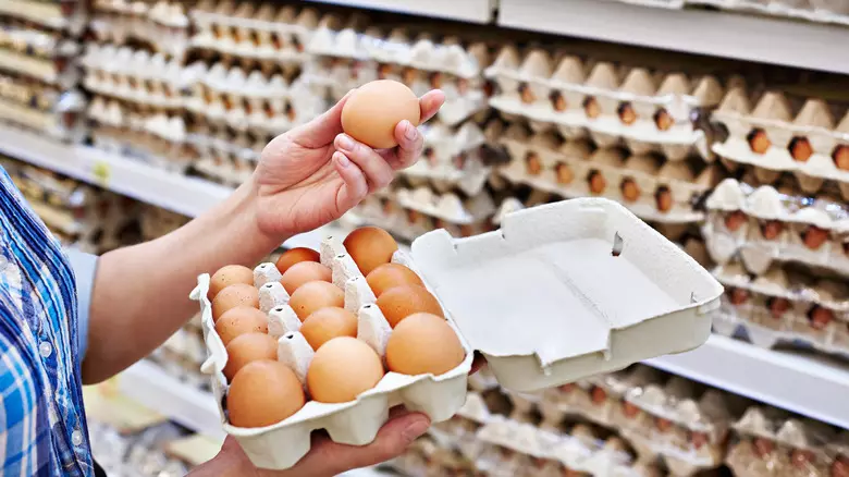 Uma pessoa comprando ovos no supermercado