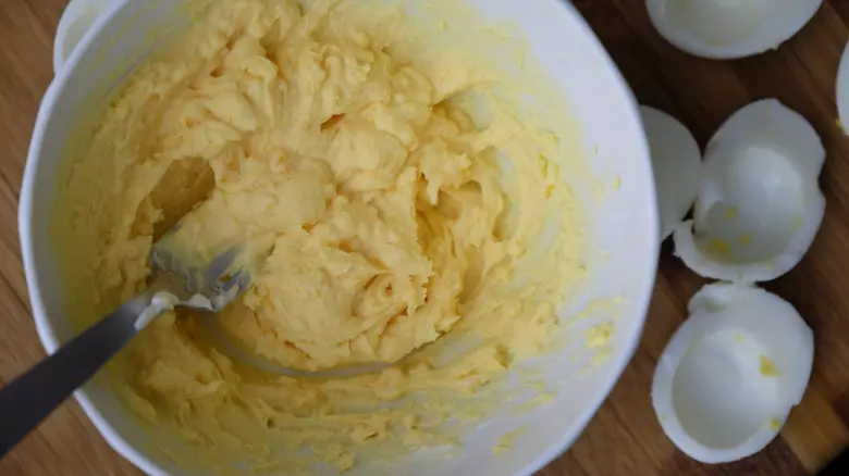 A mistura amarela fica em uma tigela ao lado de claras de ovos