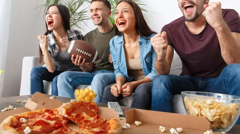צופה בכדורגל תוך כדי אכילת פיצה