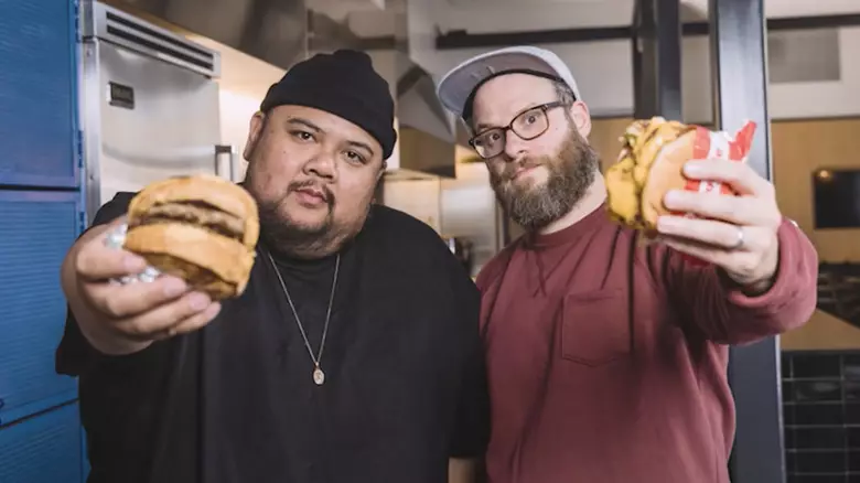 Seth Rogen und Alvin Cailan halten Burger hoch