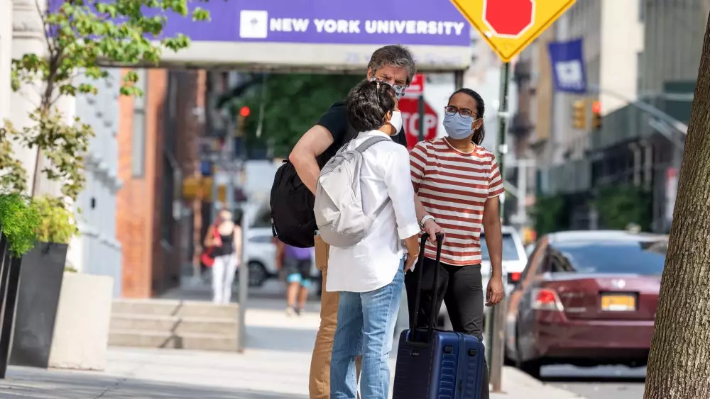 Estudantes mascarados da NYU se reúnem do lado de fora do prédio da NYU