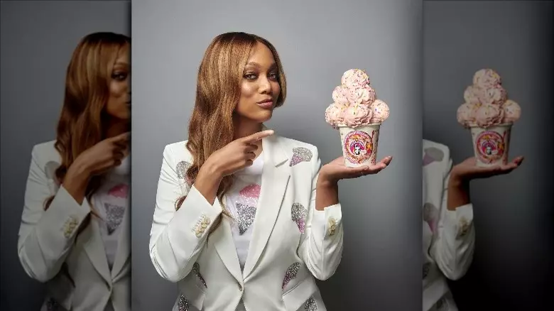 Tyra banks poserar med en kopp smize-glass