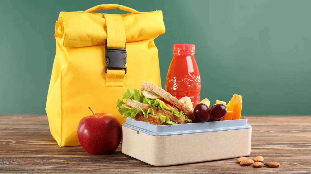 Karung makan tengah hari kuning dengan kotak makan tengah hari dengan makanan sihat