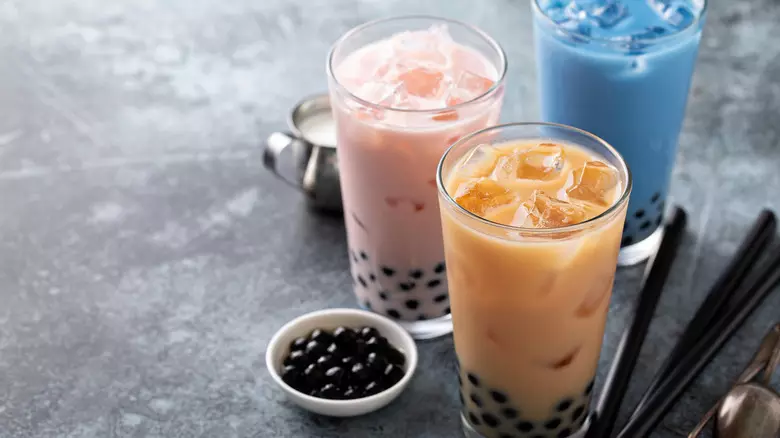 Awọn teas boba alawọ mẹta lẹgbẹẹ ekan kan ti awọn bọọlu tapioca