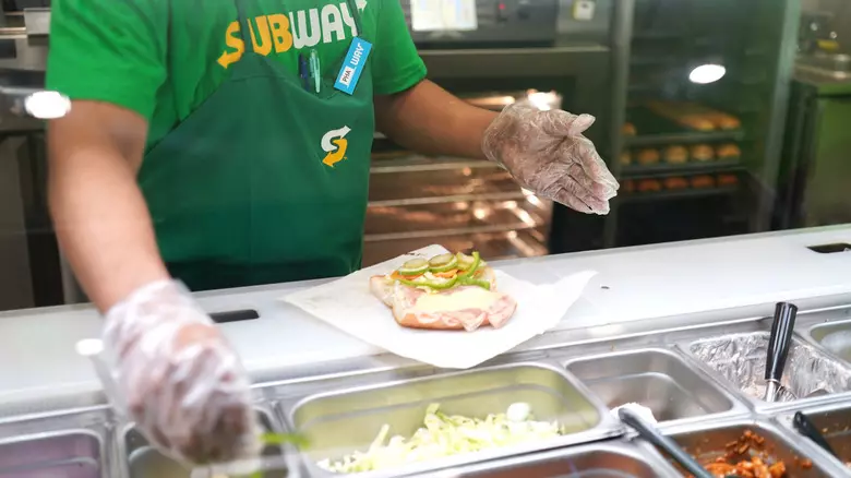 Employé du métro faisant un sandwich