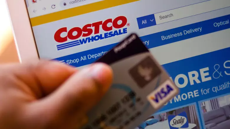 ਪਿਛੋਕੜ ਵਿੱਚ Costco, ਫੋਰਗਰਾਉਂਡ ਵਿੱਚ ਕ੍ਰੈਡਿਟ ਕਾਰਡ