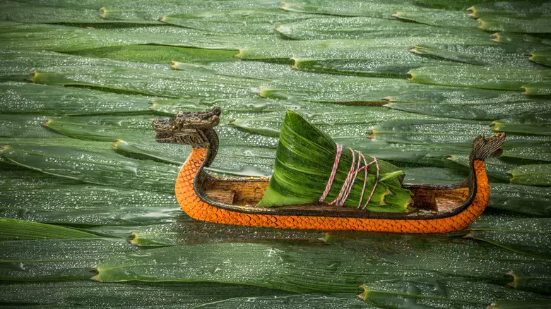 Mini dragón barco con boliñas sobre fondo de follas