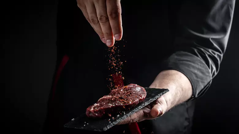 Chef-kok handen kruiden biefstuk.