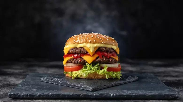 Ukudla okusheshayo i-cheeseburger ene-steam.