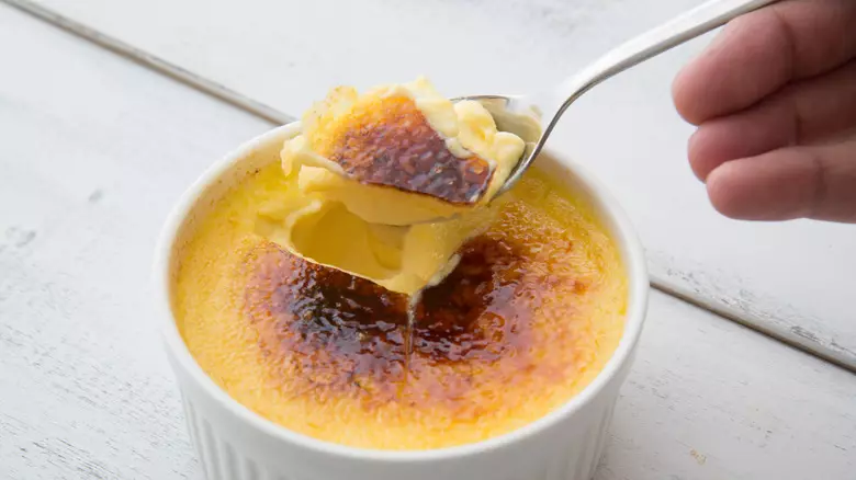 Persoană care ia o lingură de crème brûlée