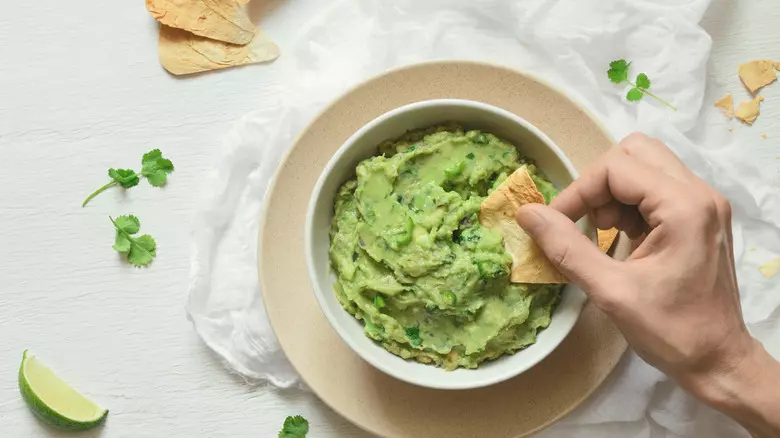 chip ya kuchovya kwa mkono kwenye guacamole