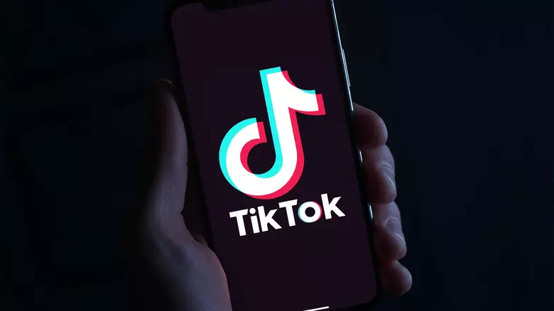 ຄົນຖືໂທລະສັບທີ່ມີໜ້າຈໍ TikTok