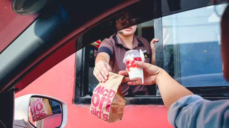 Cliente pegando sorvete do McDonald's da janela do drive thru