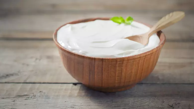 Yogur griego en tazón de madera con cuchara