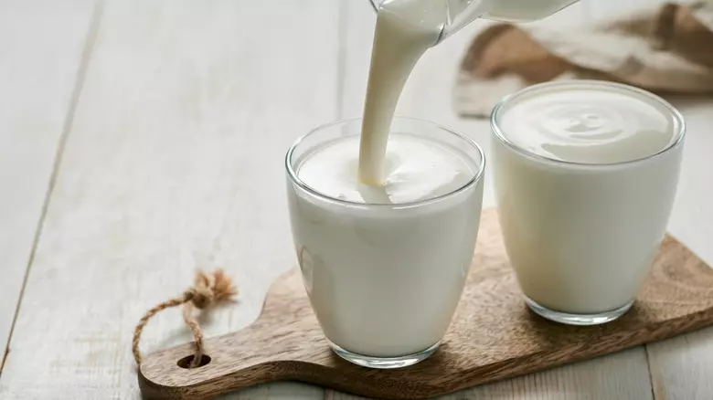 Buttermilk gegoten yn in glês op hout blok