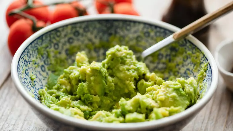 Mashed up avocado yn dekorative kom