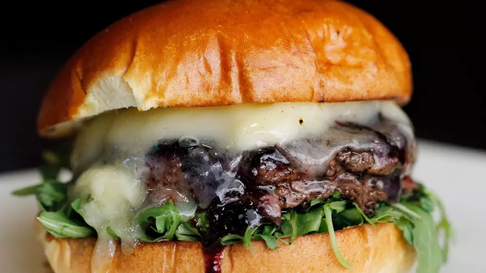 I-Burger enetshizi enyibilikisiweyo, i-lettuce kunye ne-blueberry sauce.