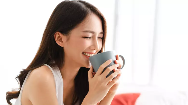 dona somrient prenent cafè
