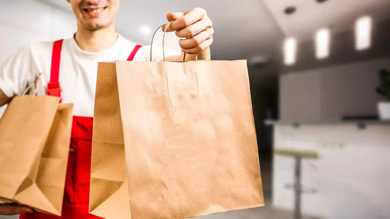 pekerja makanan cepat saji memegang tas untuk pelanggan