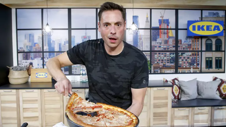 Jeff Mauro ținând o pizza