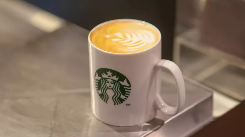 Latte ealaíne cúr i muga Starbucks