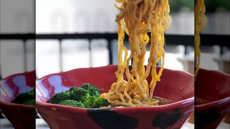 noodles na-atụgharị n'ime nnukwu efere uhie na broccoli